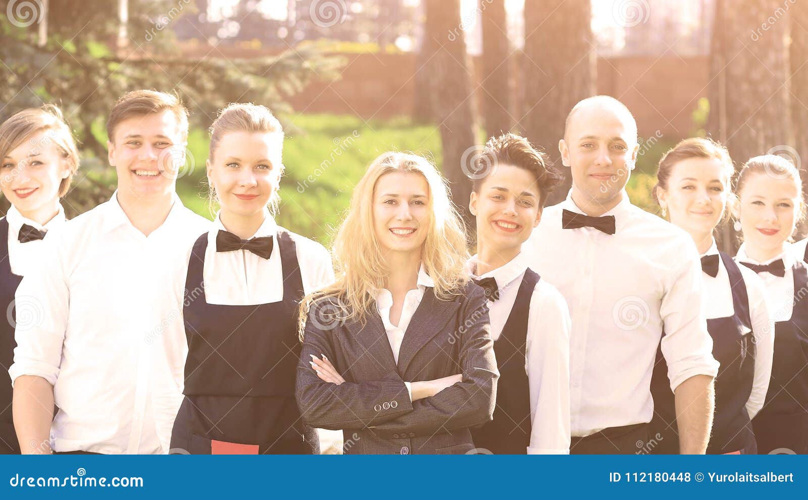 A Large Group of Friendly Waiters and Waitresses Standing in a Row ...