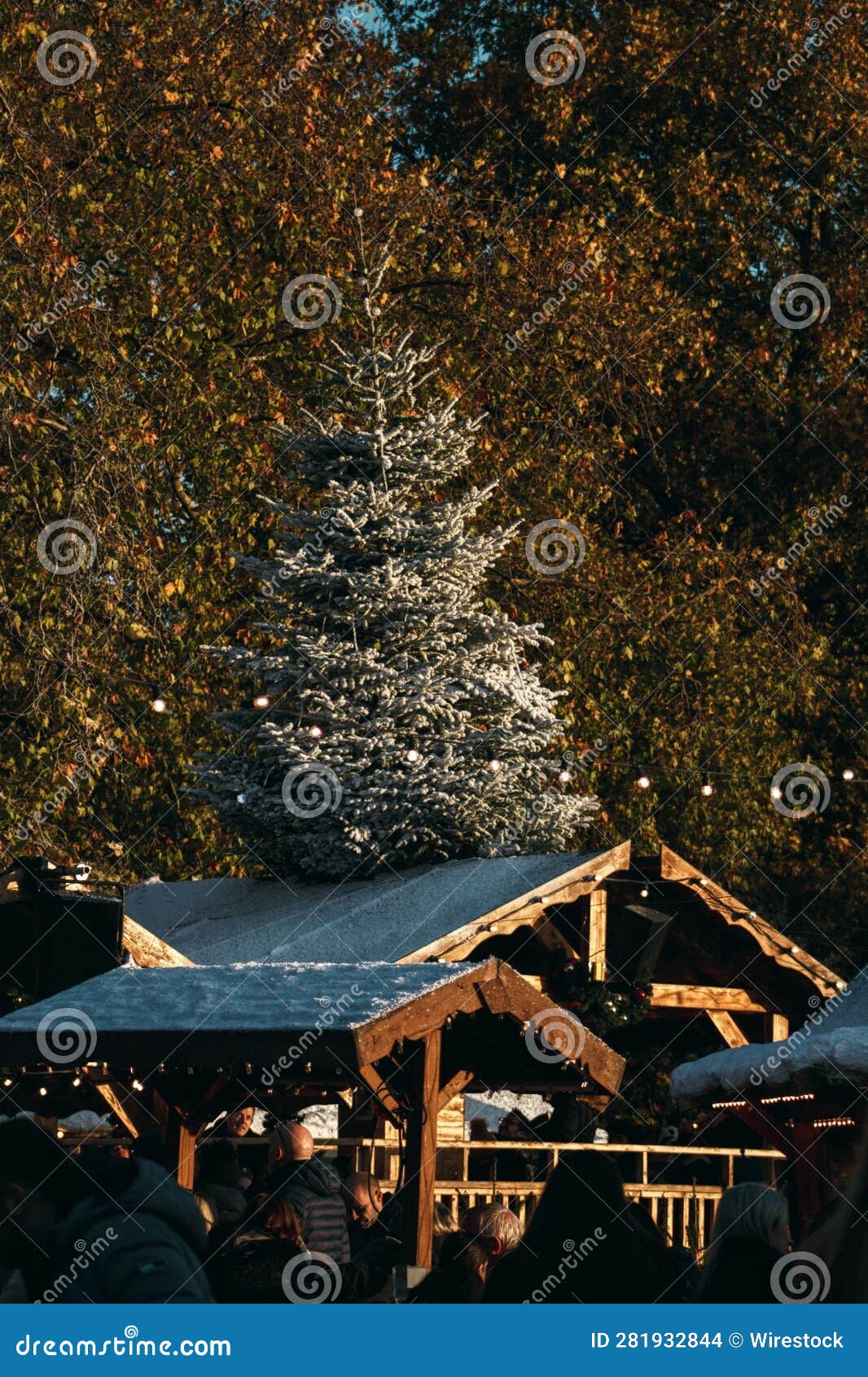 A Large Group of People Gathered in Front of a Gaze with an Evergreen ...