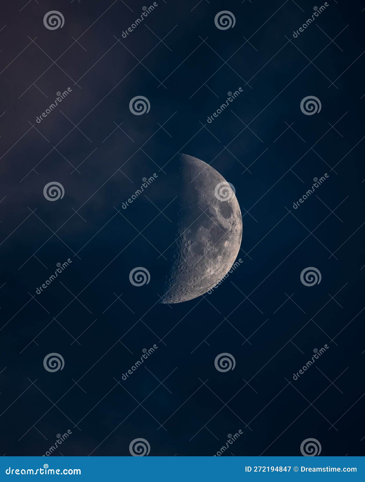 Large Half Moon Partially Obscured by Clouds in the Night Sky with a ...
