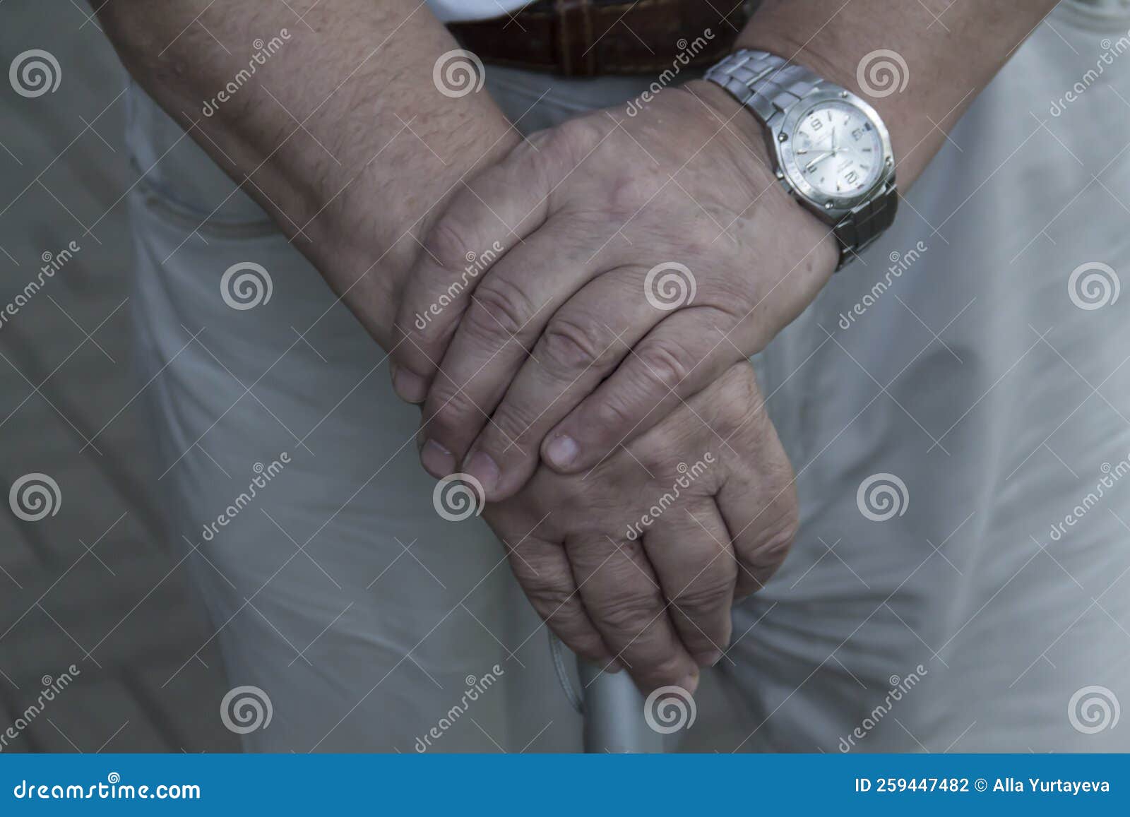The Large Hands of an Elderly Man are Folded on a Cane with a Watch on ...