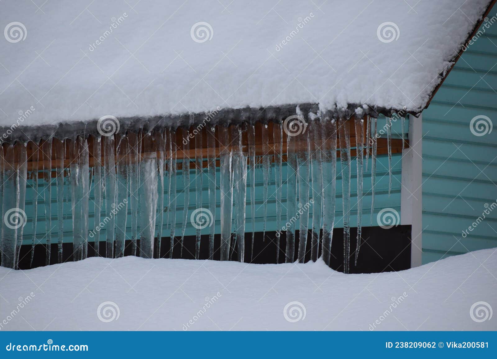 Large Ice Icicles Hang from Roof. Ice Falling Hazard Stock Photo ...