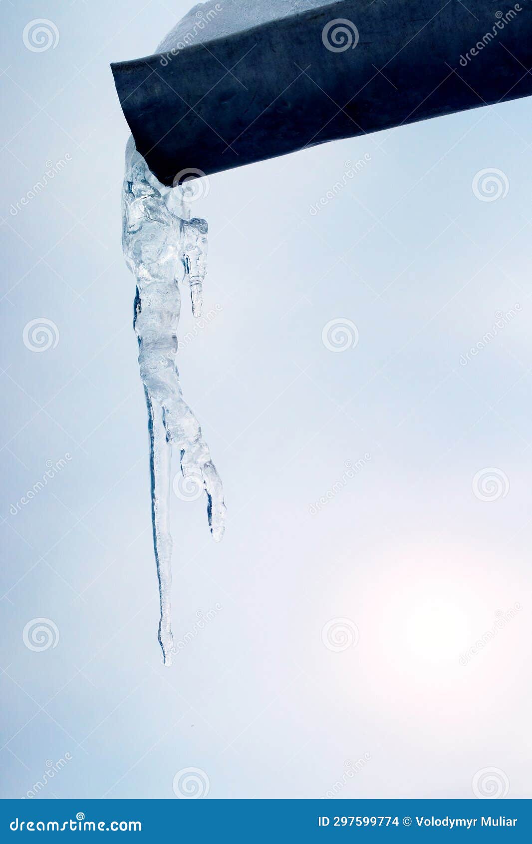 A Large Icicle Hangs from a Gutter in Winter in Sunny Weather Stock ...
