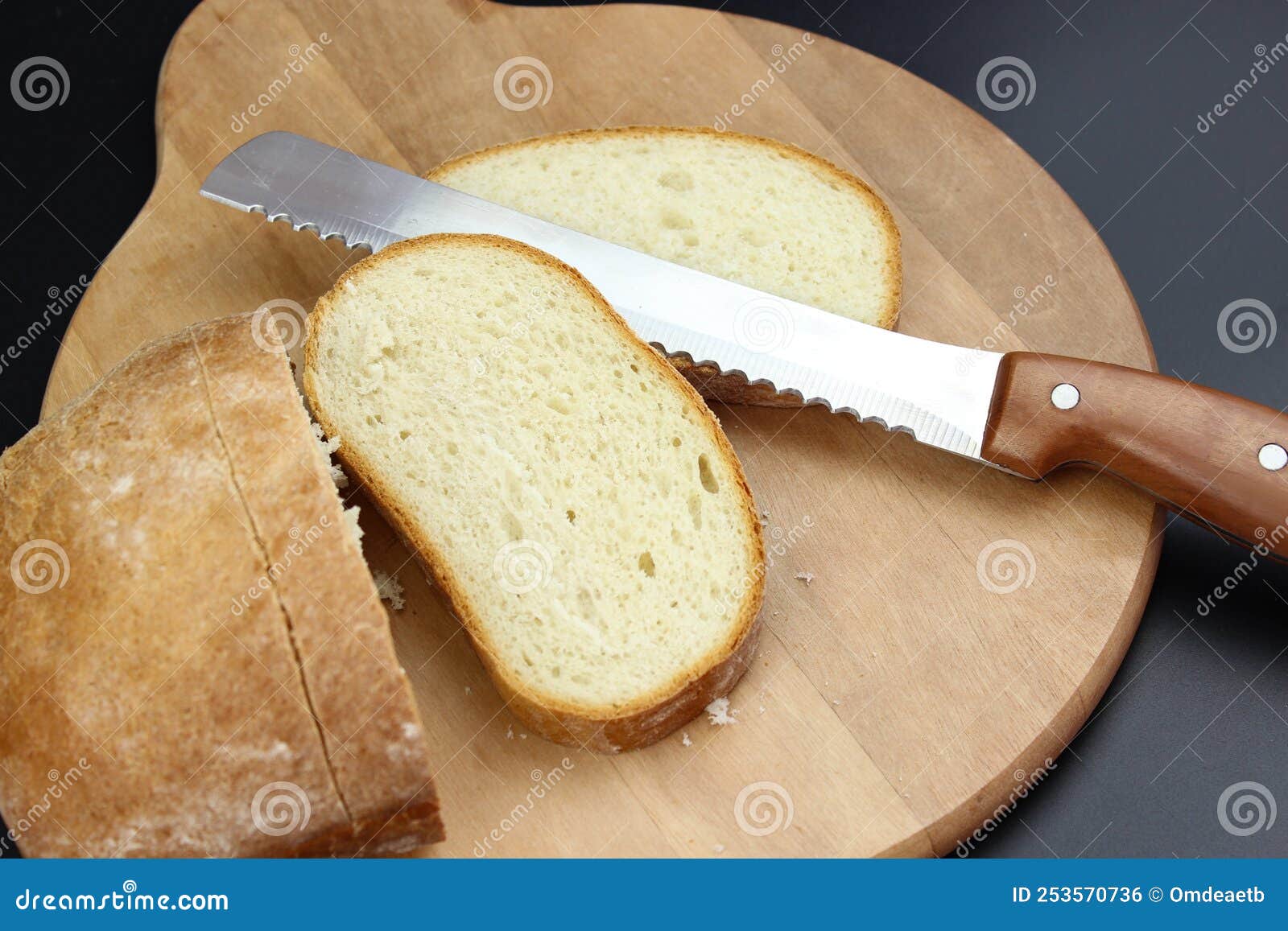 A Large Knife Cuts Thin Pieces of White Bread from a Rectangular Loaf ...