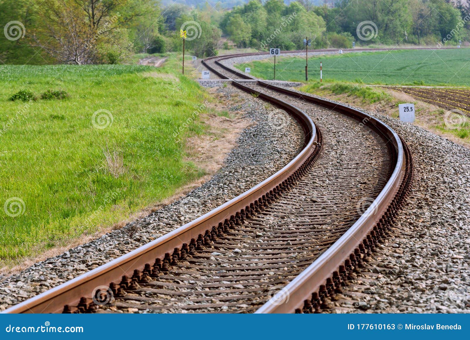 A Large Long Train on a Train Track with Trees in the Background Stock ...