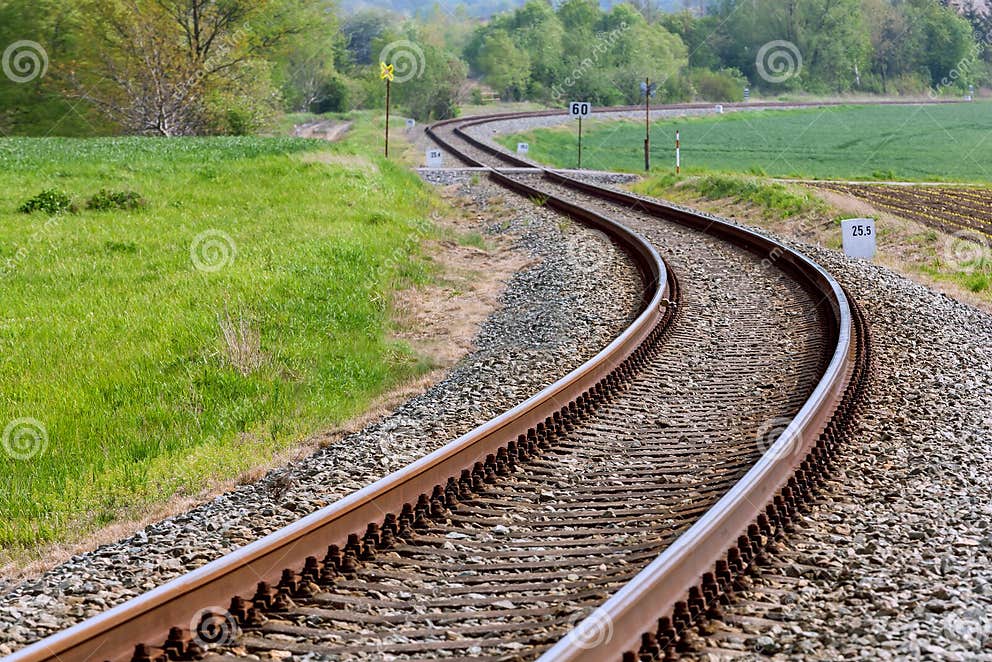 A Large Long Train on a Train Track with Trees in the Background Stock ...