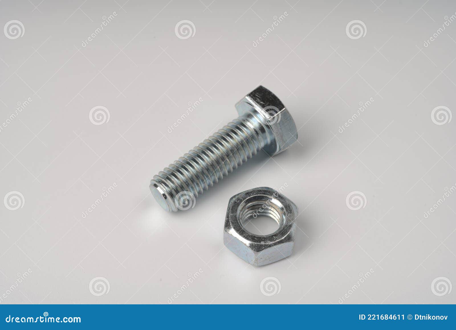 A Large Metal Threaded Bolt and a Nut for it Side by Side on a White ...