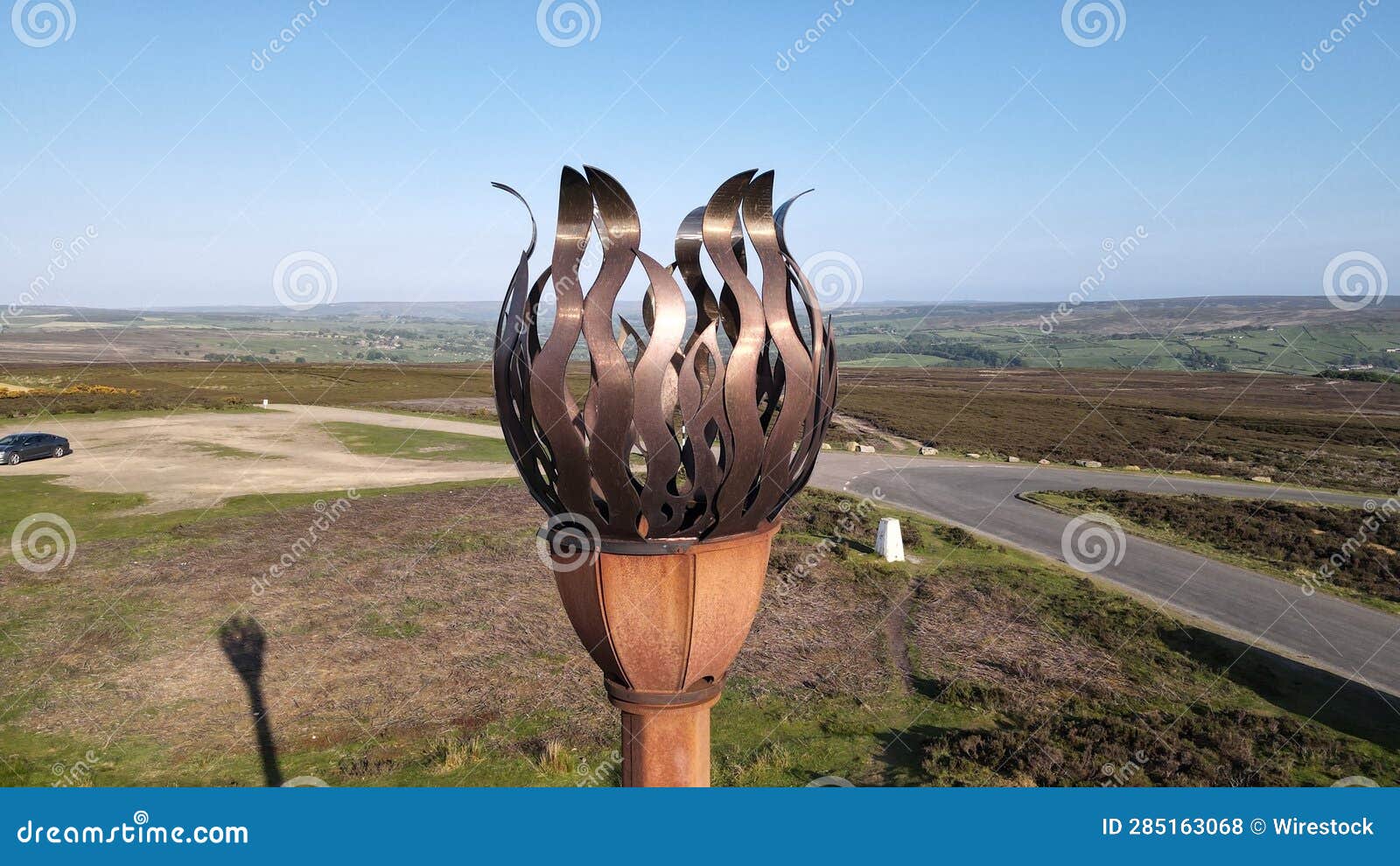 Large Metallic Sculpture of a Torch is Prominently Displayed Atop a ...