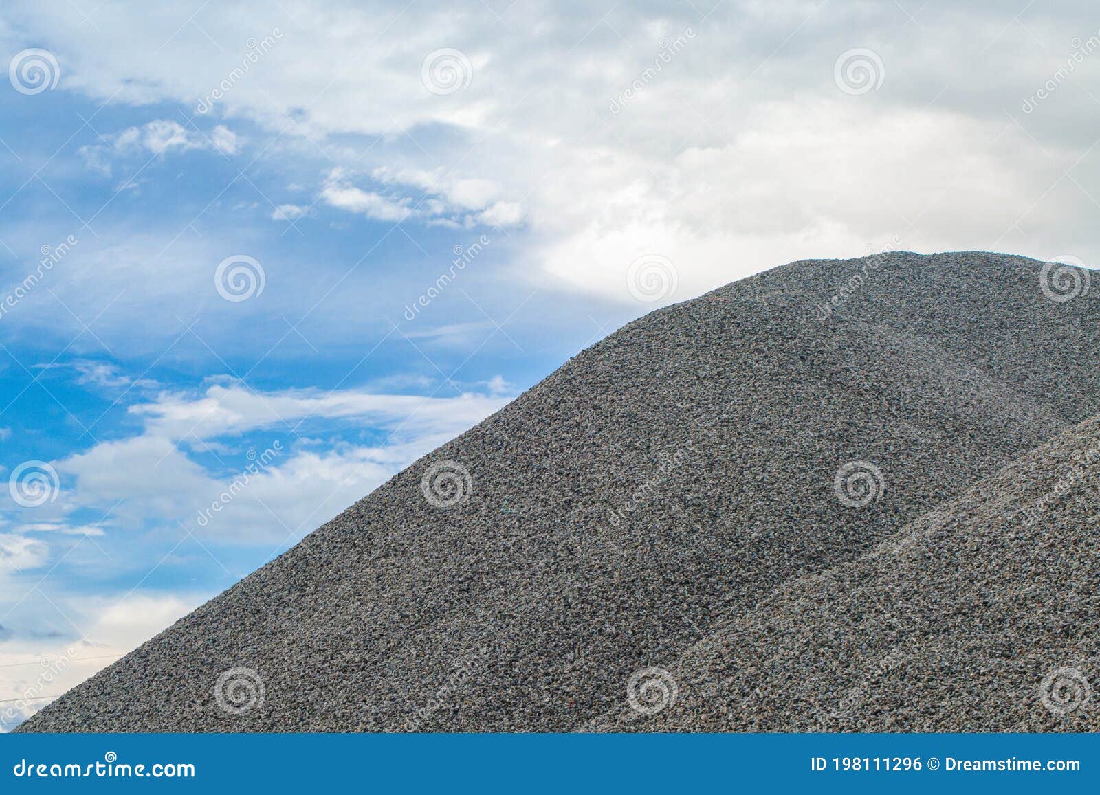 A Large Mountain of Rubble, Against a Blue Sky with Clouds Stock Photo ...