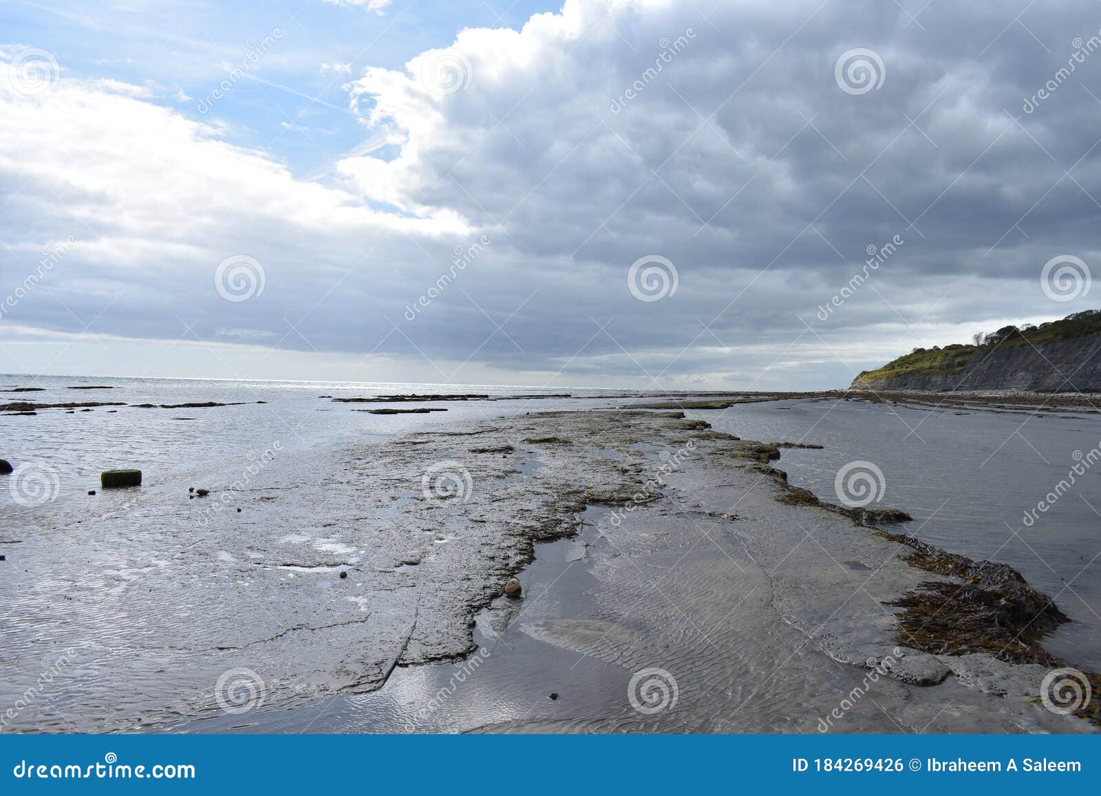 Mud Flat with Ocean Waves and Bright Cloudy Sky Stock Photo - Image of ...