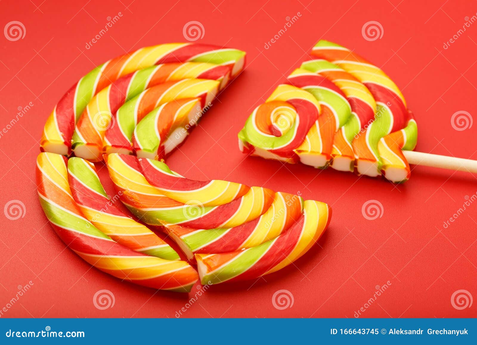 A Large Multi-colored Lollipop Split into Pieces, on a Scarlet ...