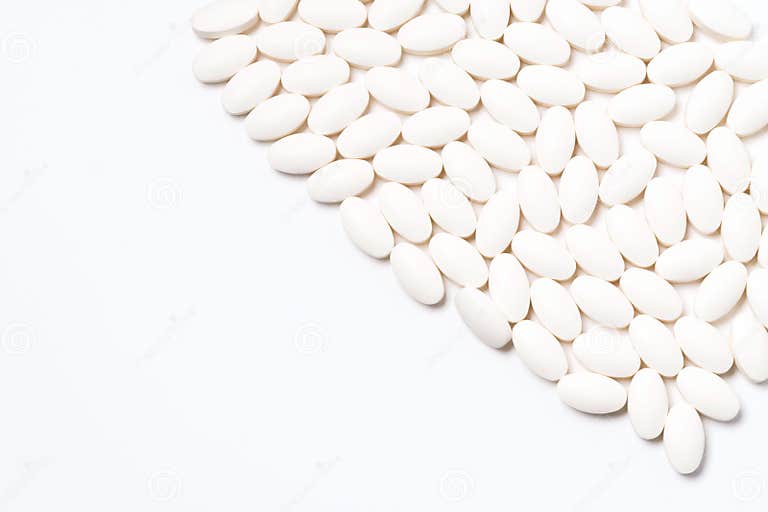 A Large Number of Tablets of White Oval-shaped Tablets on a White ...