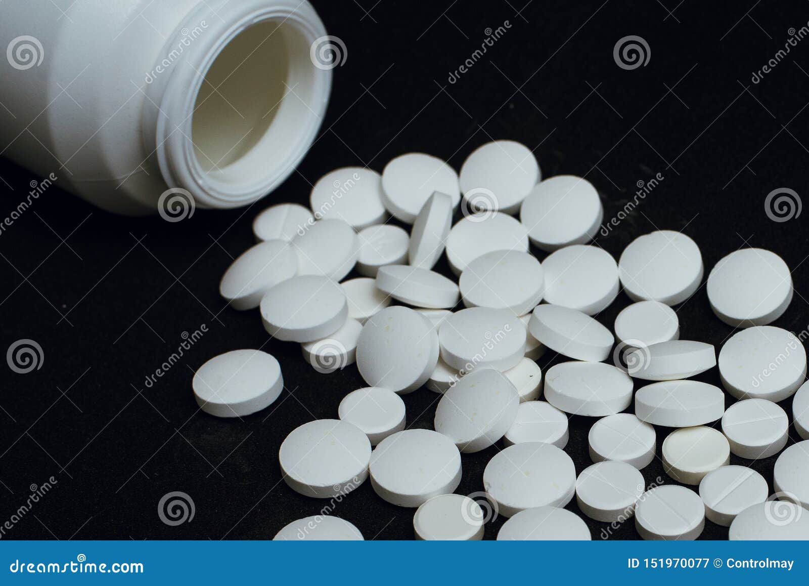 A Large Number of White Tablets Scattered from the Container on a Black ...