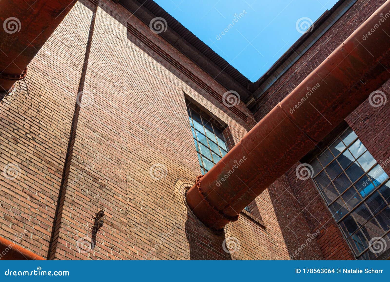 Large Pipe Emerging from a Brick Wall on the Inside Corner of an ...