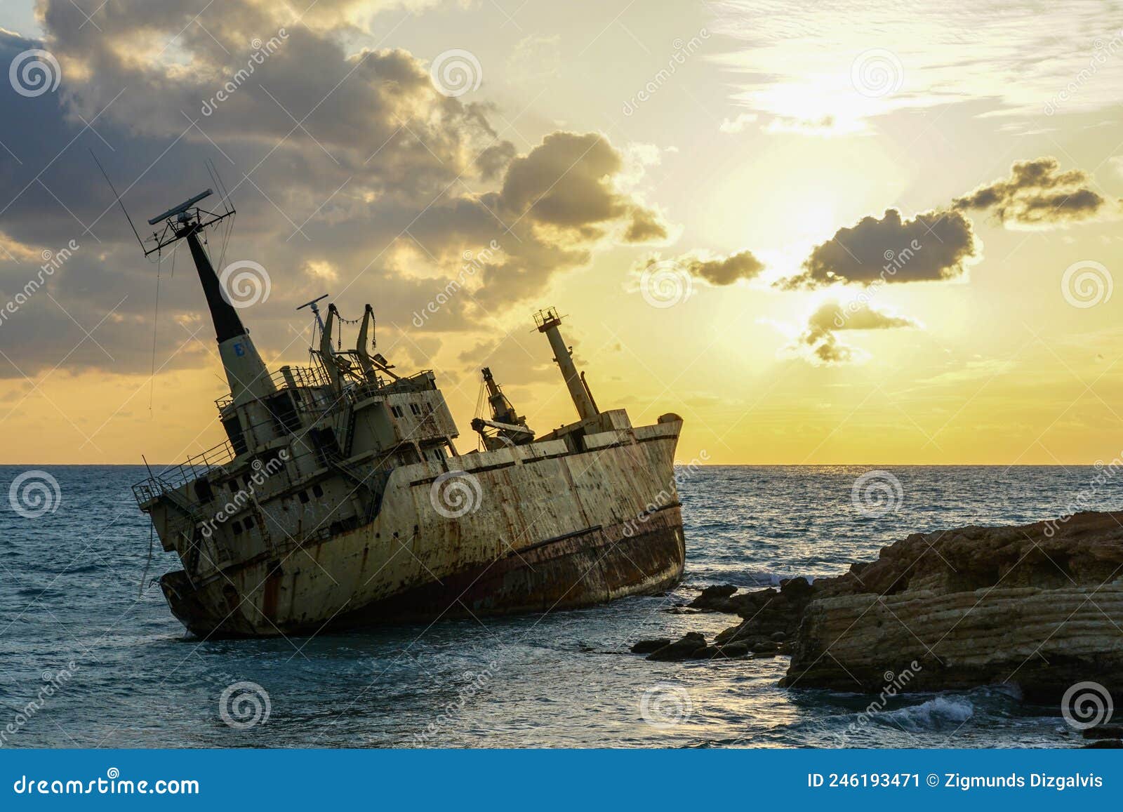 A Large Rusty Shipwreck on a Rocky Coast Against a Beautiful Sunset ...