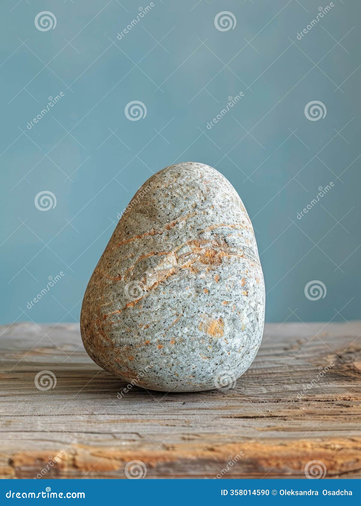 Large Smooth Rock on Wooden Surface with Blue Background Stock Photo ...