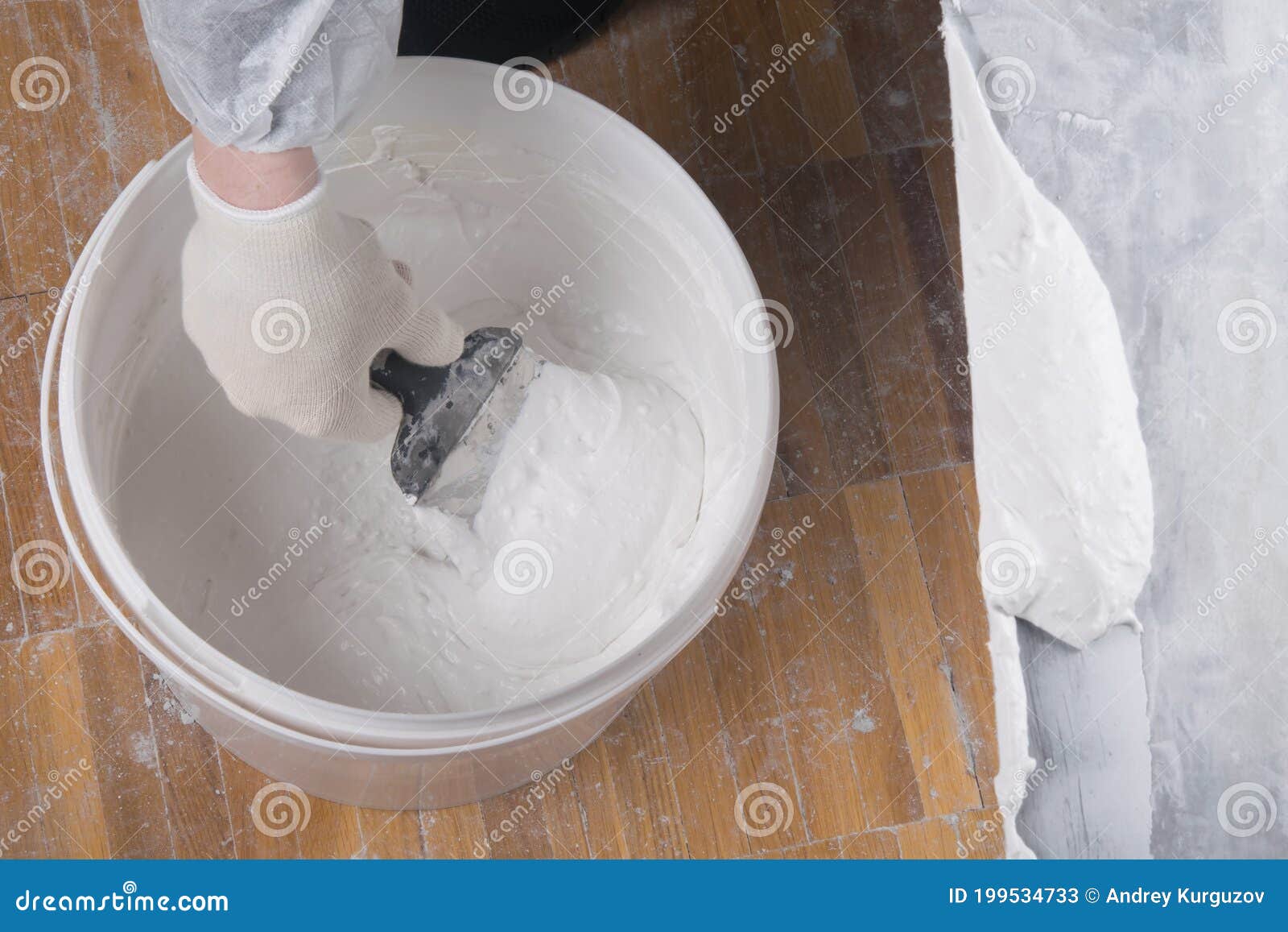 On a Large Spatula Apply a Mixture for Sealing Cracks from a Bucket ...