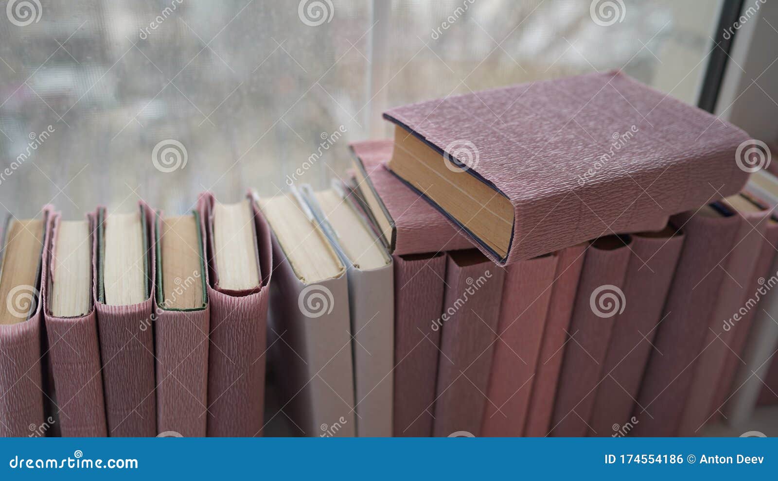 Large Stack of Books on Windowsill. Books Wrapped in Colored Paper Lie ...