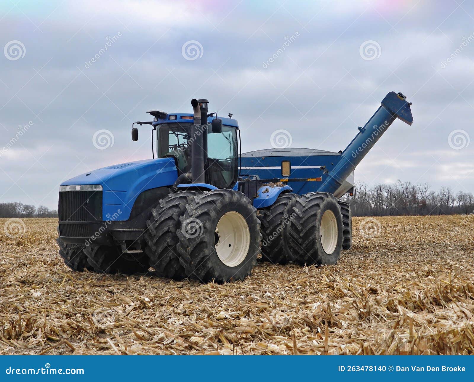 Large Tractor Pulling a Grain Cart in a Harvested Corn Field Stock ...