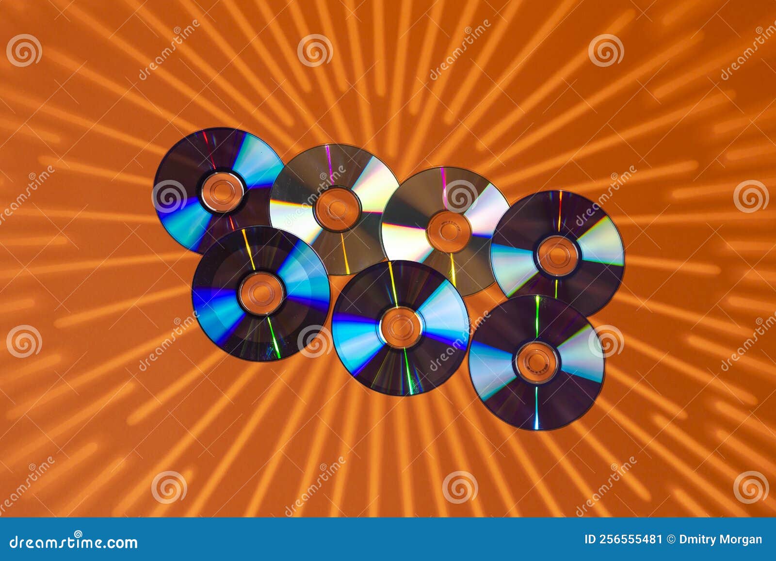 Large Variety Of Arranged Cd Disks Or Dvd Disks On Orange Background With Different Circular