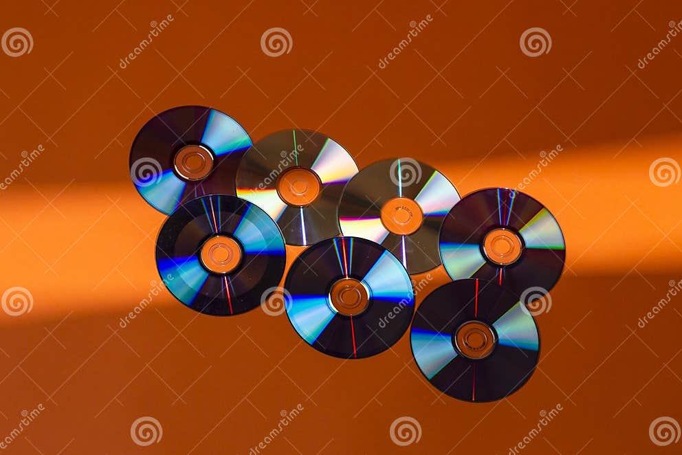 Large Variety of Arranged CD Disks or DVD Disks on Orange Background ...