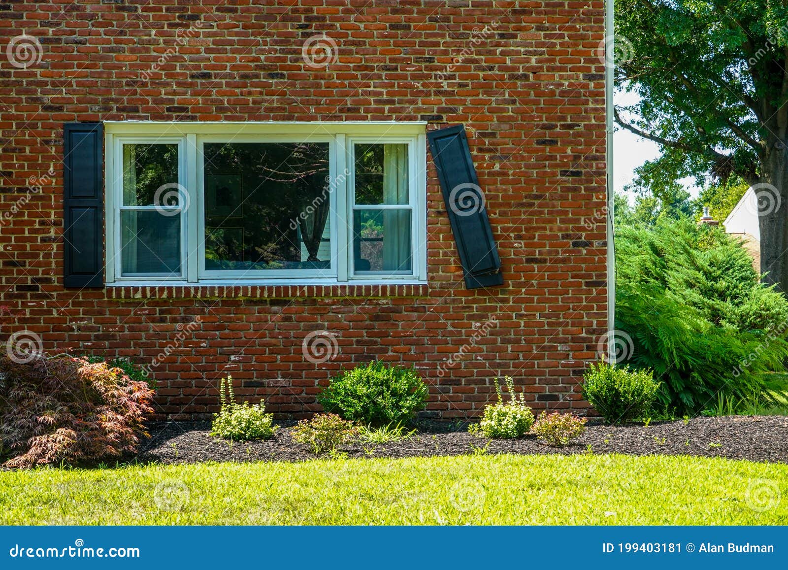 Large Window on the Brick Front Wall of a House with a Black Shutter ...