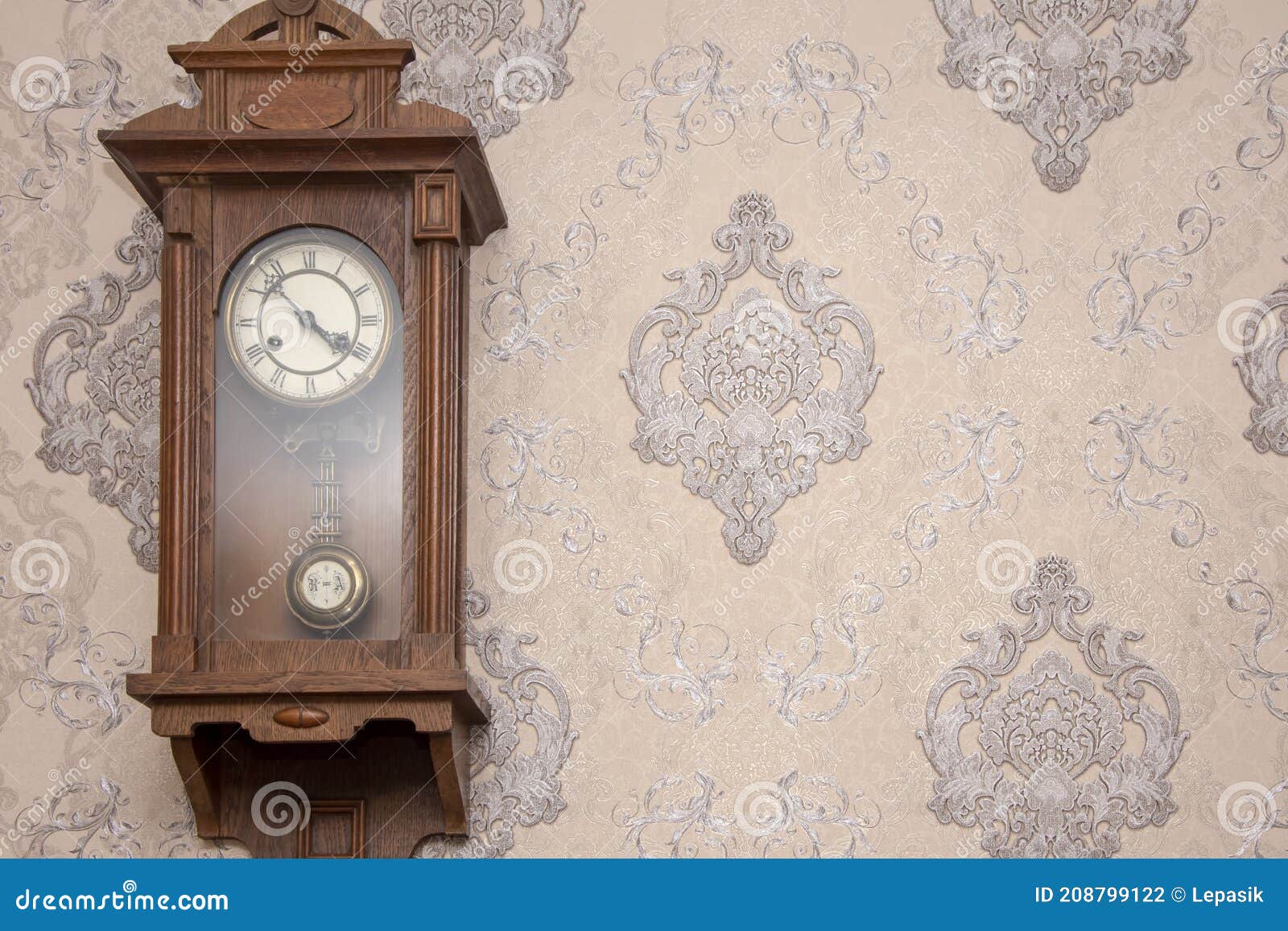 A Large Wooden Wall Clock with a Pendulum Hangs on the Wall. Stock ...