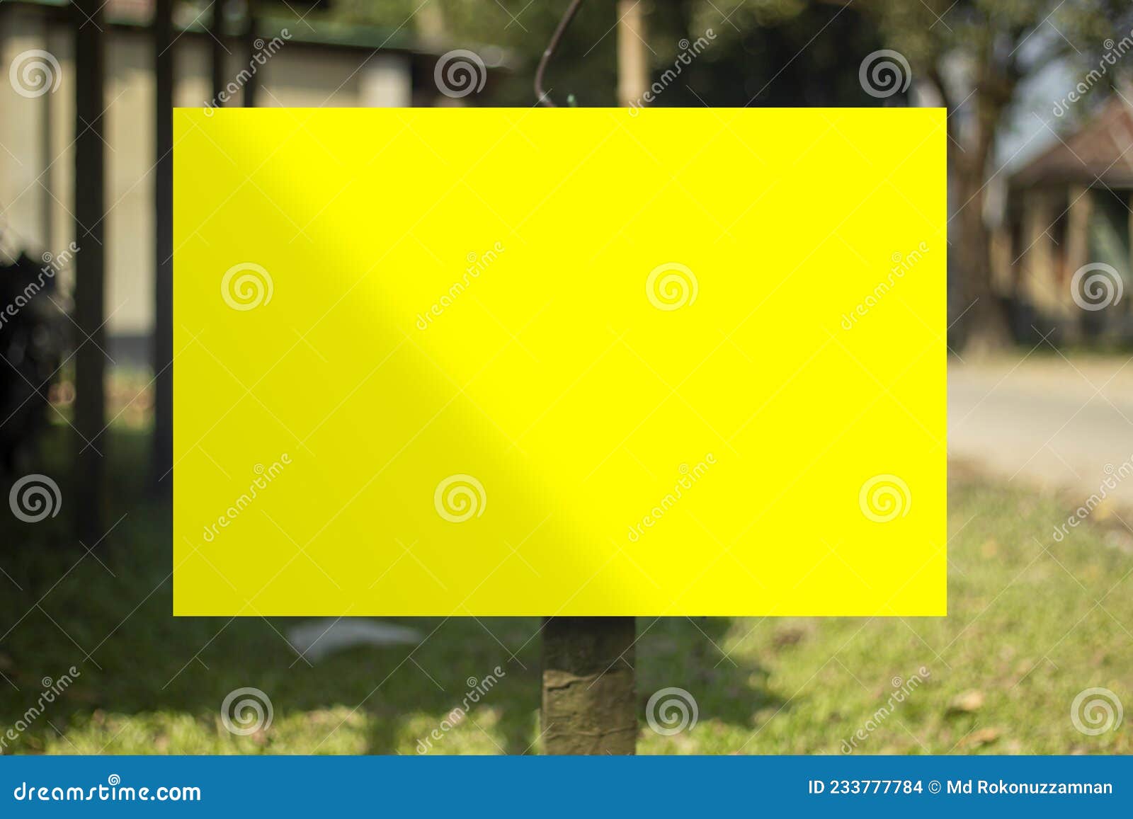 A Large Yellow Sign Board Hanging with a Pole and the Background Blur ...