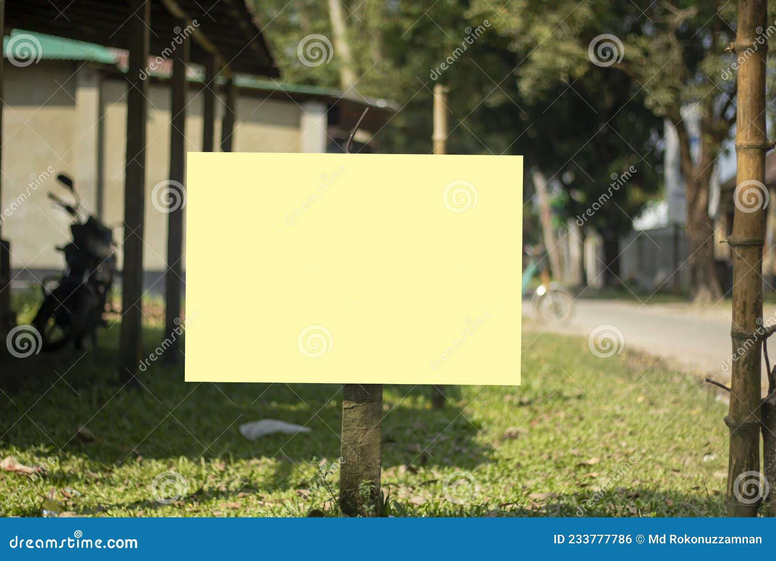 A Large Yellow Sign Board Hanging with a Pole and the Background Blur ...