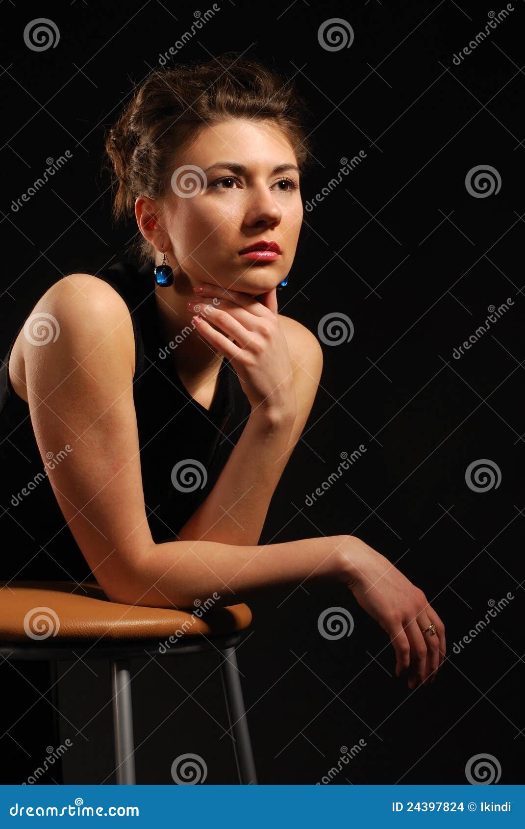 Las Endechas Hermosas Del Brunette En Una Silla Foto de archivo ...