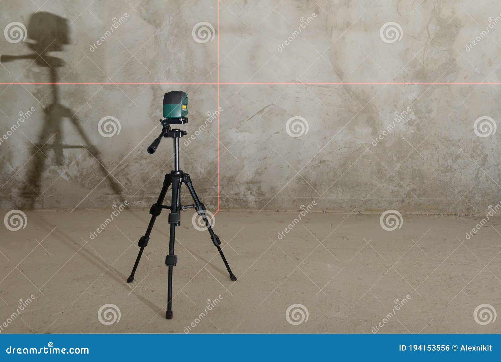 The Laser Level Stands on a Tripod and Projects Its Beams Onto a Wall ...