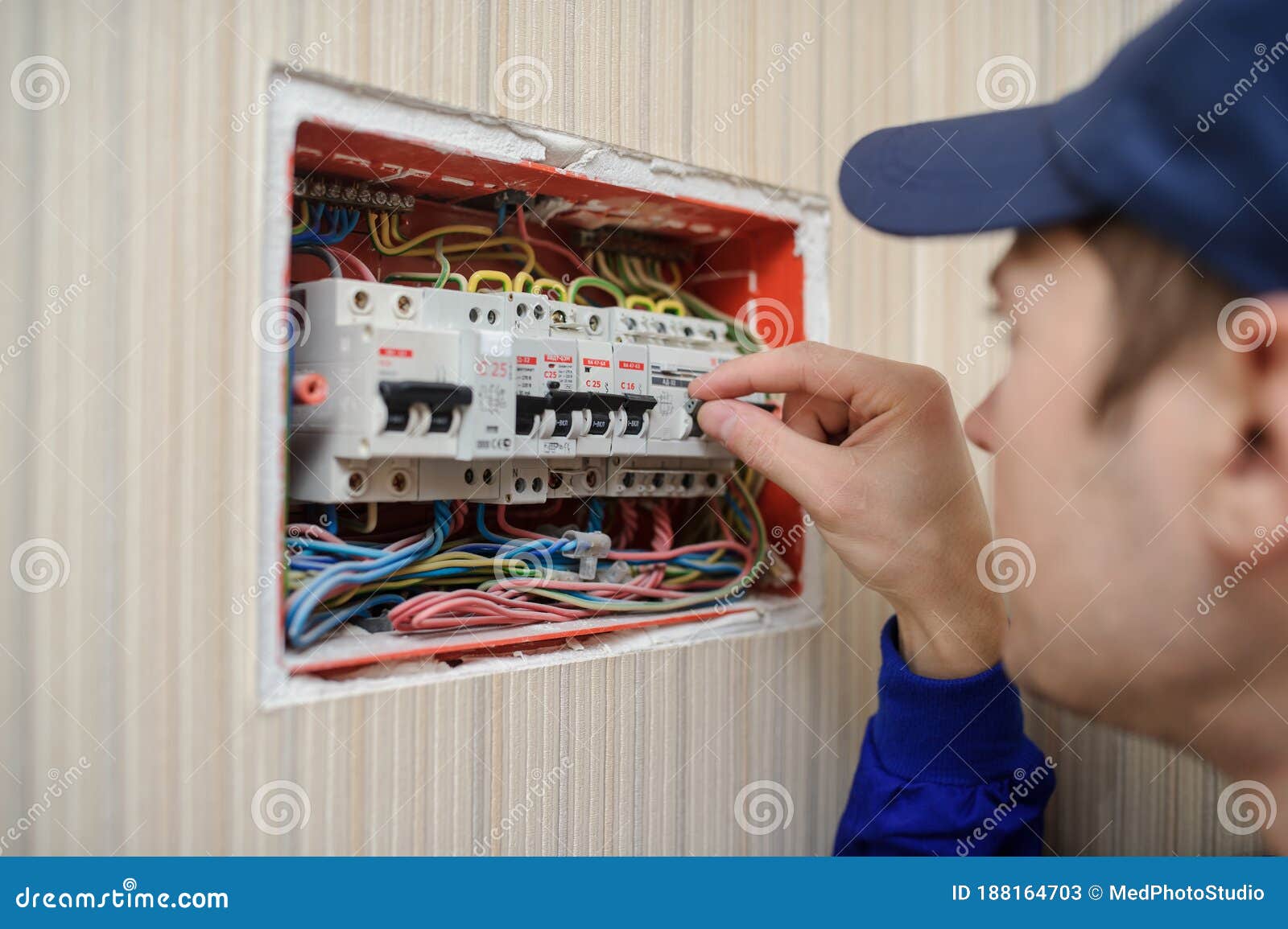Lateral View of a Young Electrician in Blue Overall Disassembling a ...