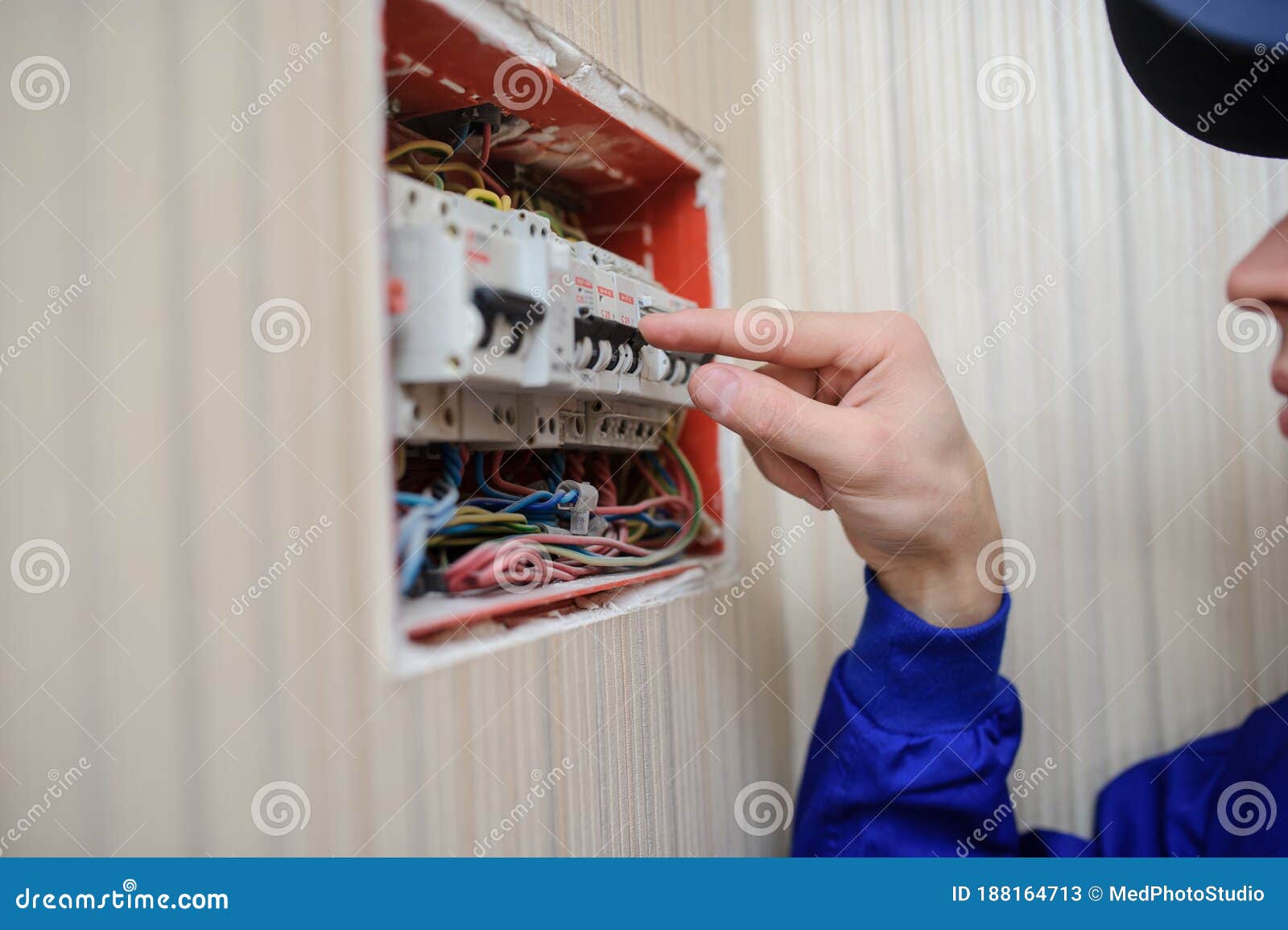 Lateral View of a Young Electrician in Blue Overall Disassembling a ...