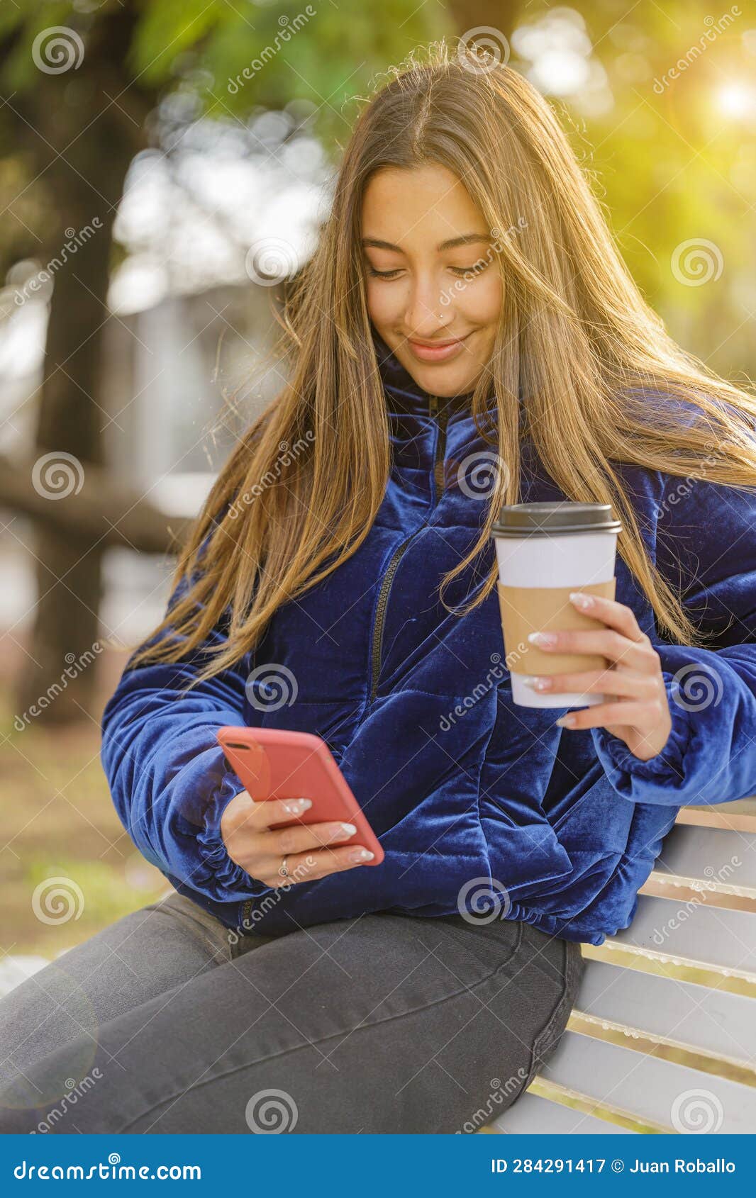 Latin Girl Sitting On A Bench In A Public Park Drinking Coffee And