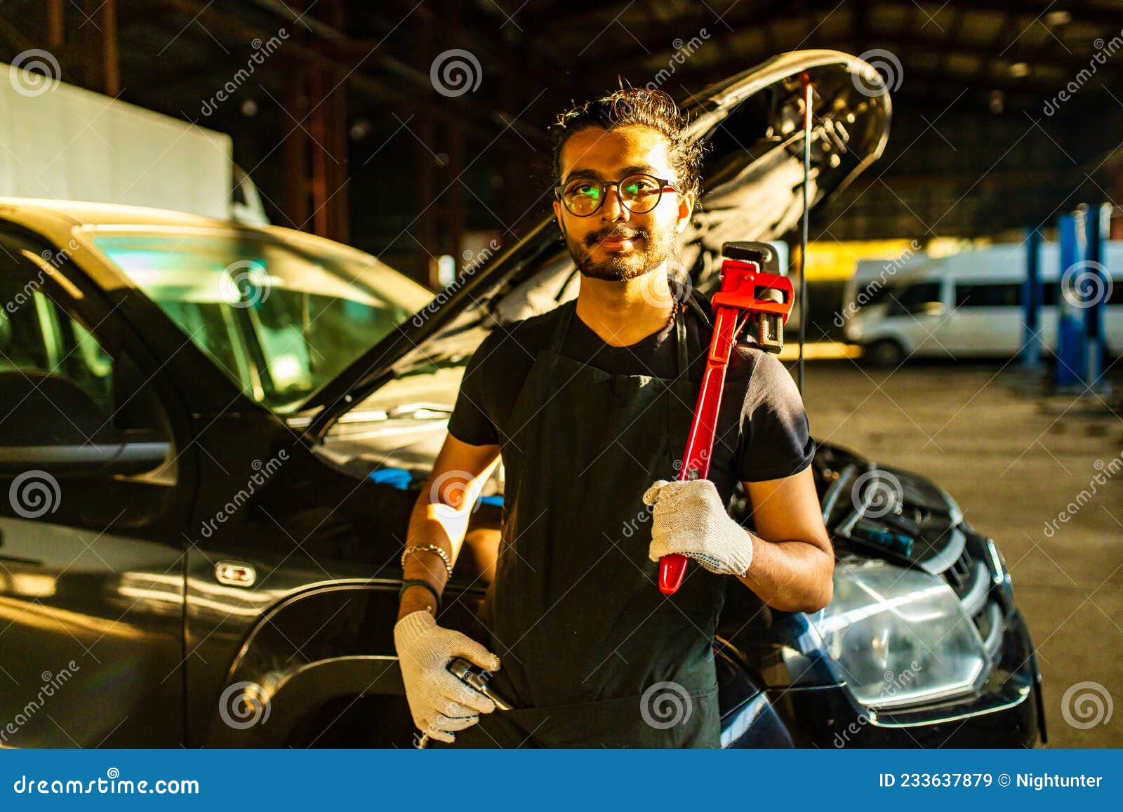 Latin Hispanic Auto Mechanic in Uniform is Examining a Car while ...