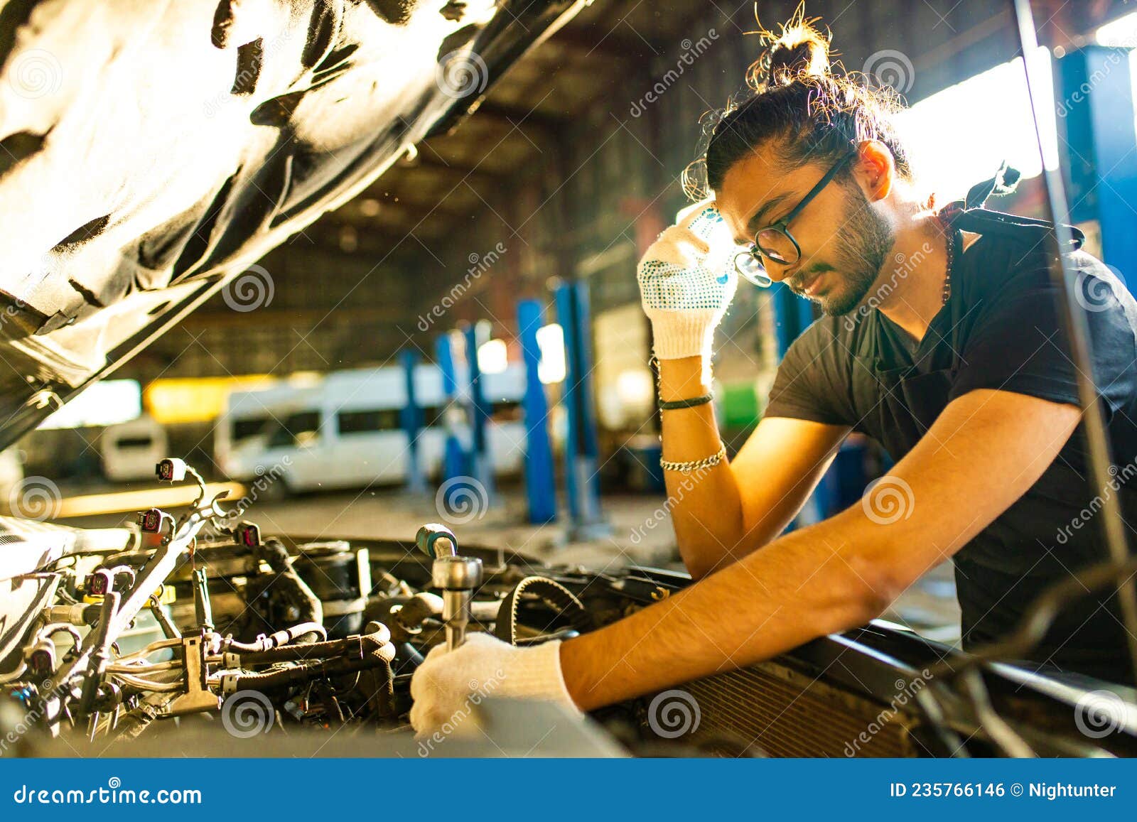 Latin Hispanic Auto Mechanic in Uniform is Examining a Car while ...