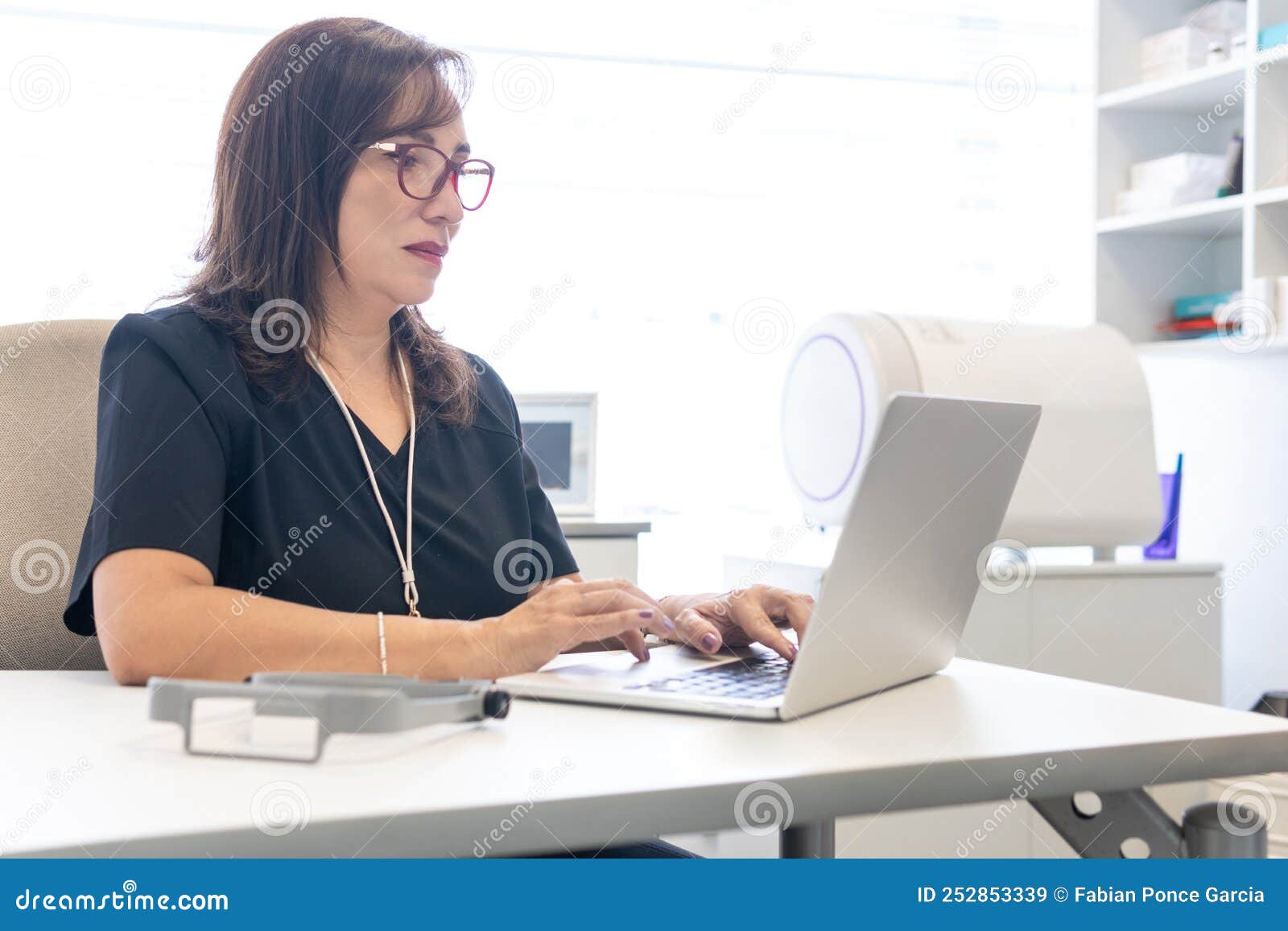 Latina Dermatologist in Her Office Working on Her Computer Stock Image ...
