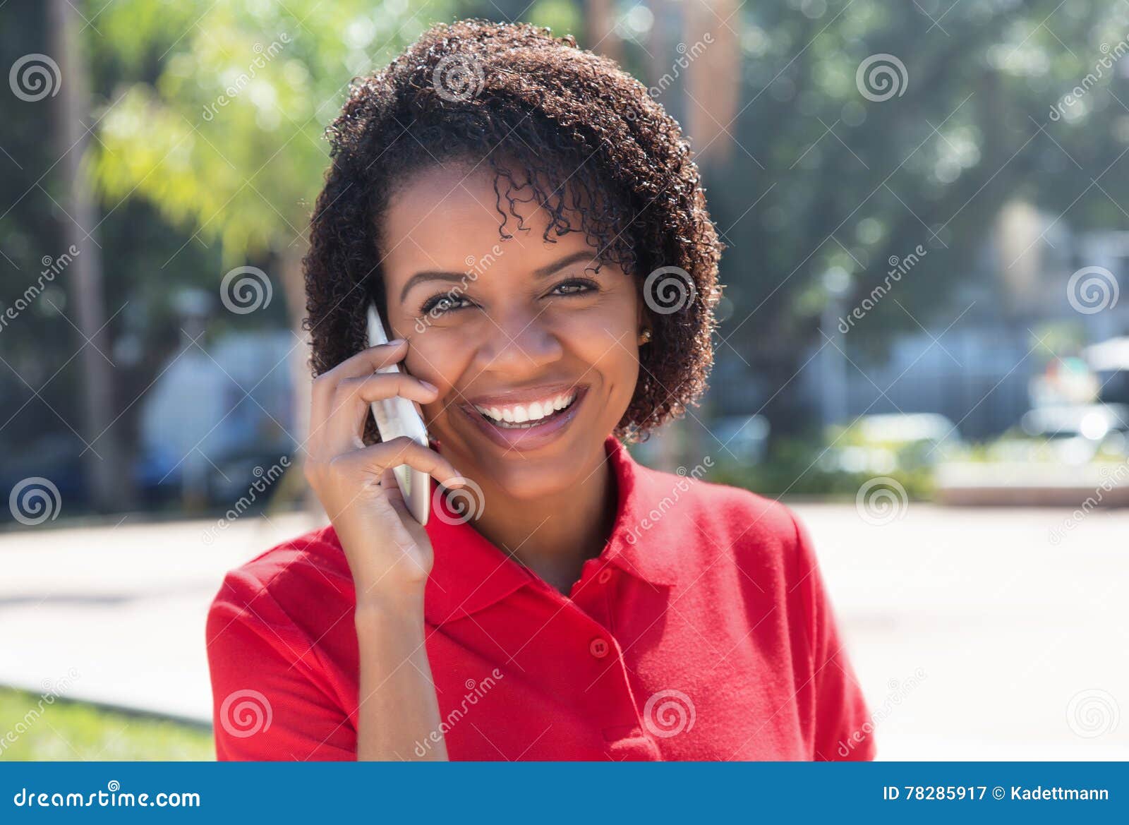Laughing African American Woman Talking At Mobile Phone In City Stock
