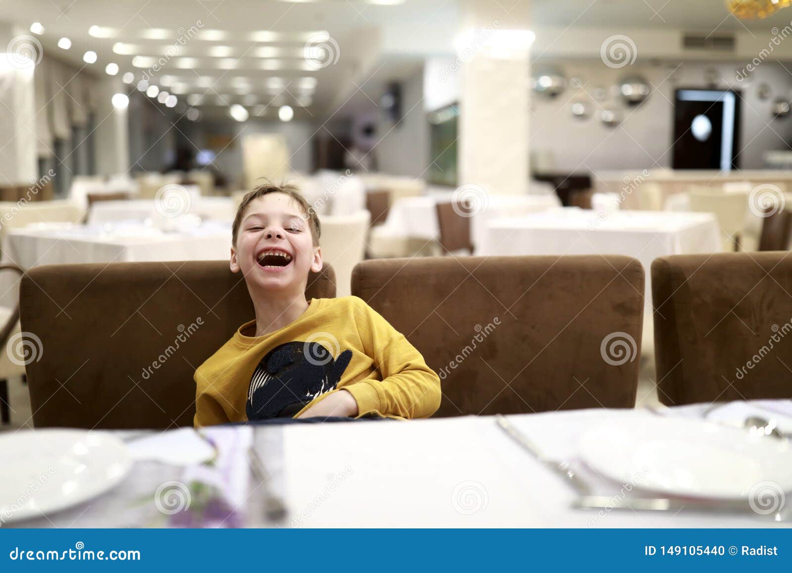 Laughing boy in restaurant stock photo. Image of cheerful - 149105440