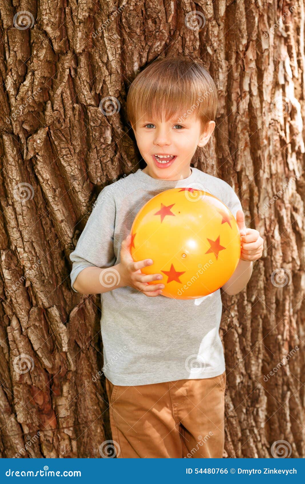 Laughing Boy Standing Under Tree with Rubber Ball Stock Photo - Image ...