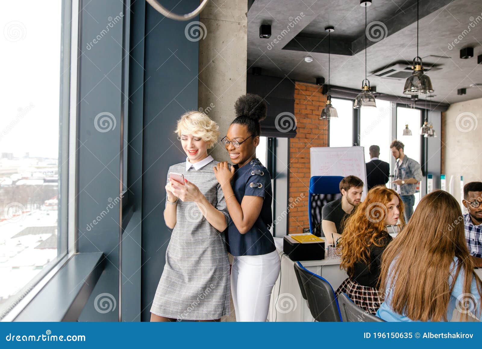 Laughing Co-workers Using Smart Phone during Break at Work Stock Image ...