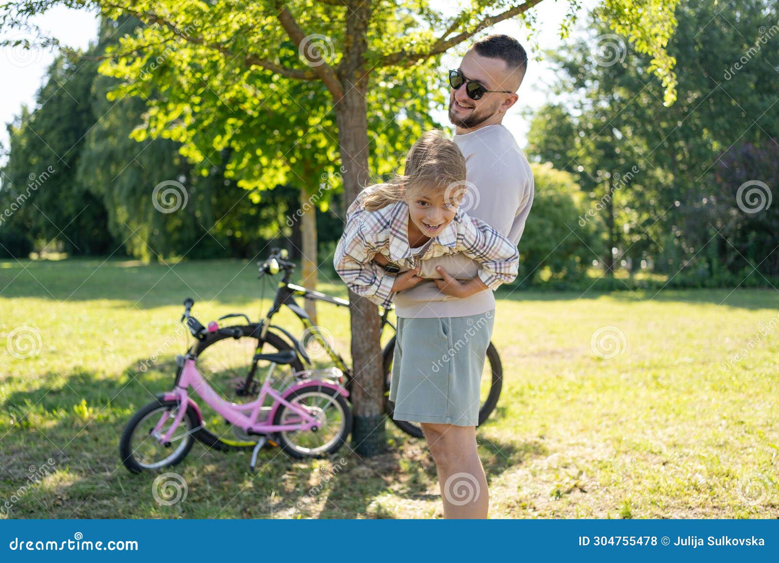Laughing Father And His Daughter Having Fun Together At The Green Park