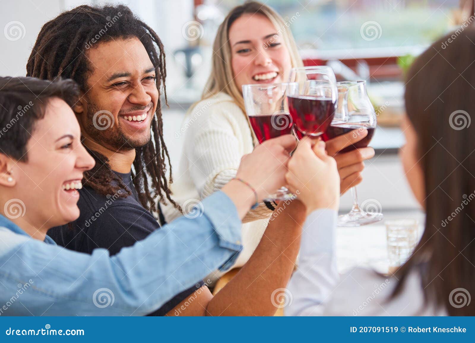 Laughing Friends Clink Glasses Of Red Wine Together At Home Stock Image