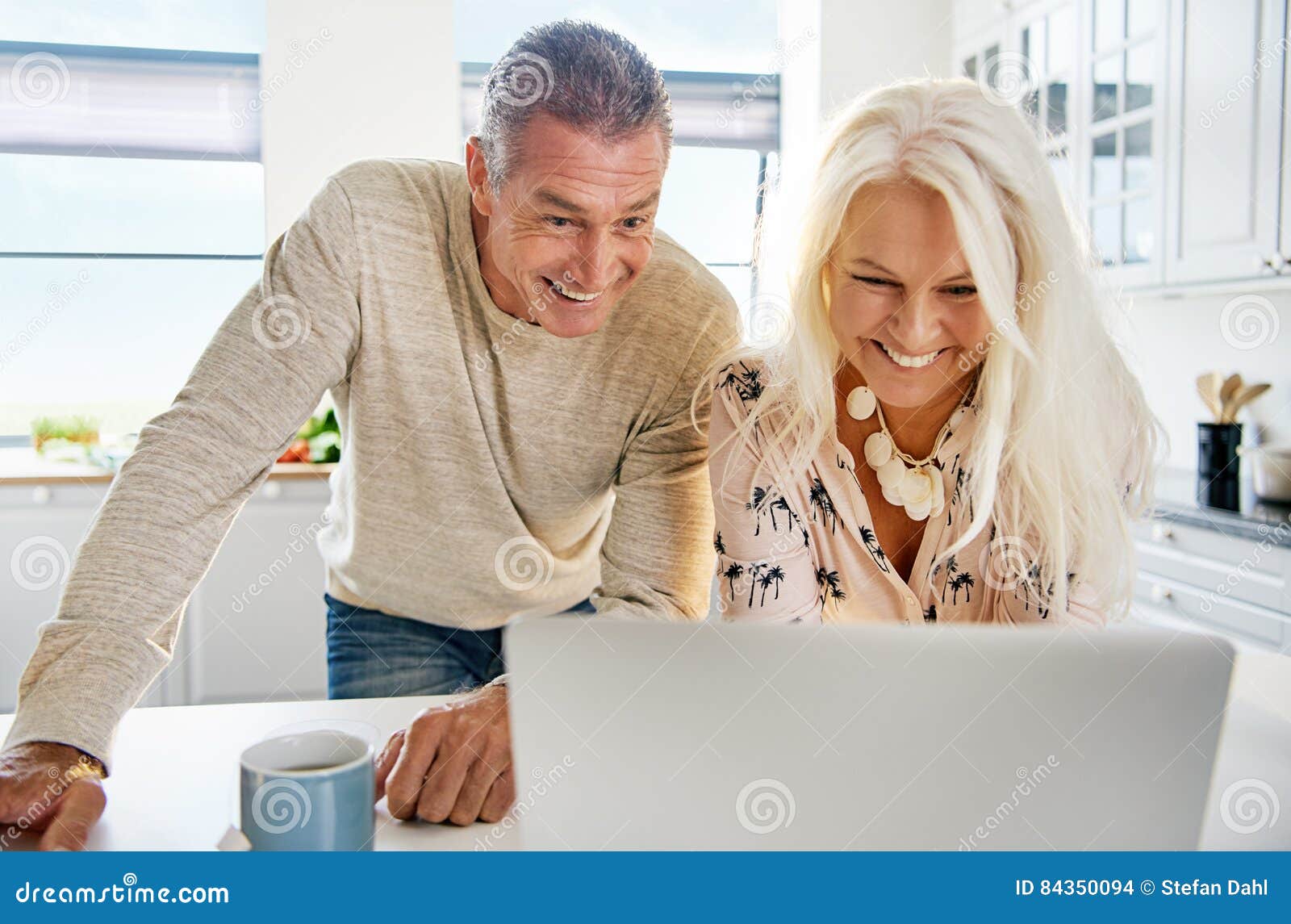 Laughing Middle Aged Couple Looking at Computer Stock Photo - Image of ...