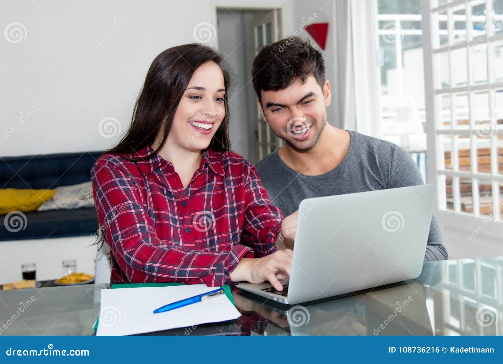 Laughing Young Couple Using Computer at Home Stock Photo - Image of ...