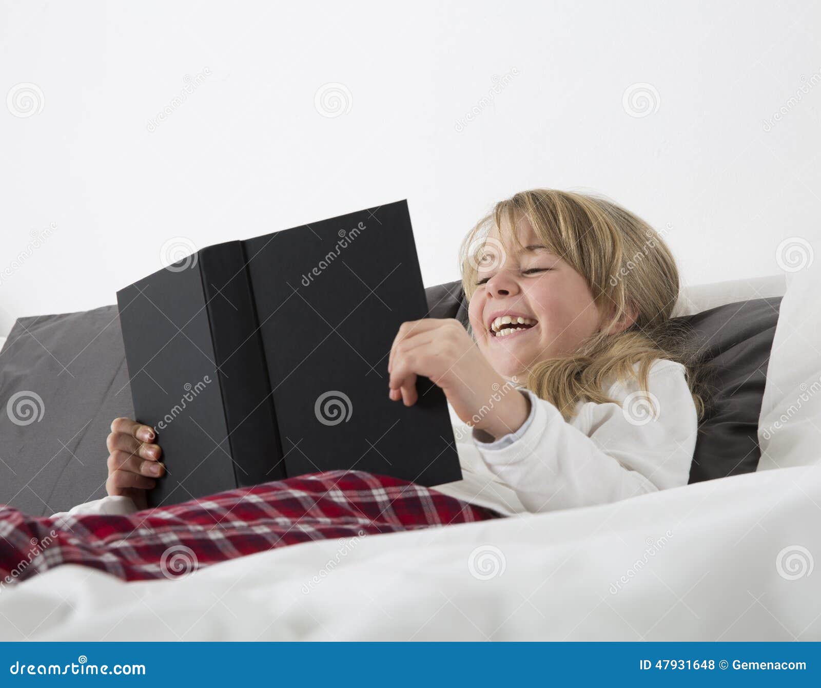 Laughing Young Girl Reading a Book Stock Photo - Image of everyday ...