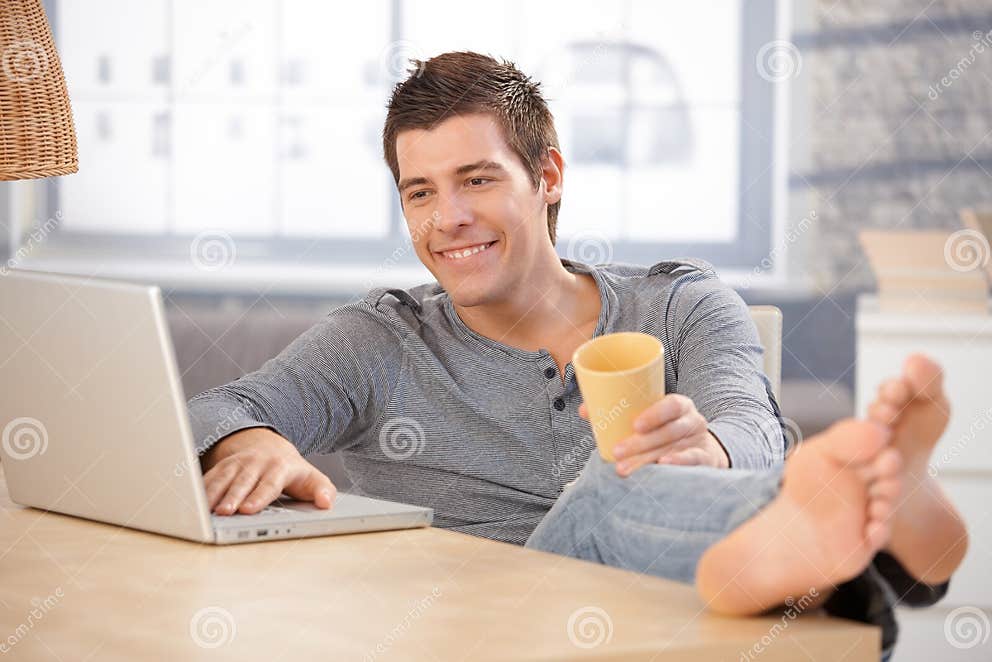 Laughing Young Man Using Computer at Home Stock Image - Image of coffee ...