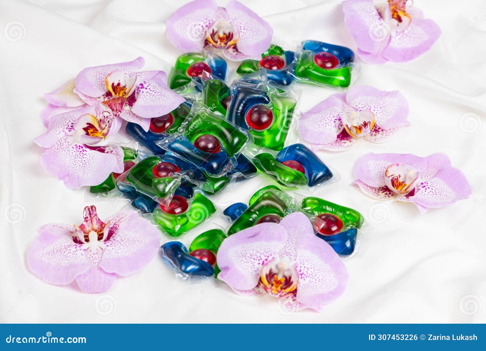 Laundry Capsules among Orchid Flowers on Satin Fabric. Stock Photo ...