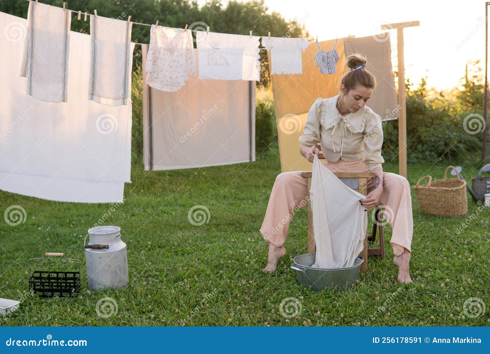 Laundry Day A Woman Hangs Linen And Towels On A Tree In The Courtyard