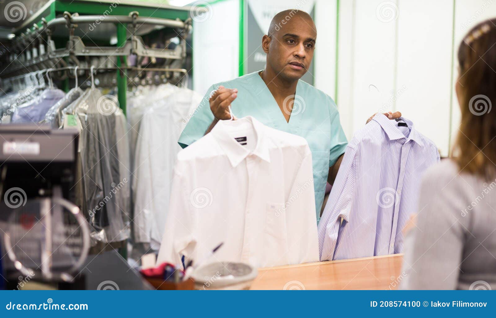 Laundry Employee Handing Out Clean Clothes To Client Stock Photo ...