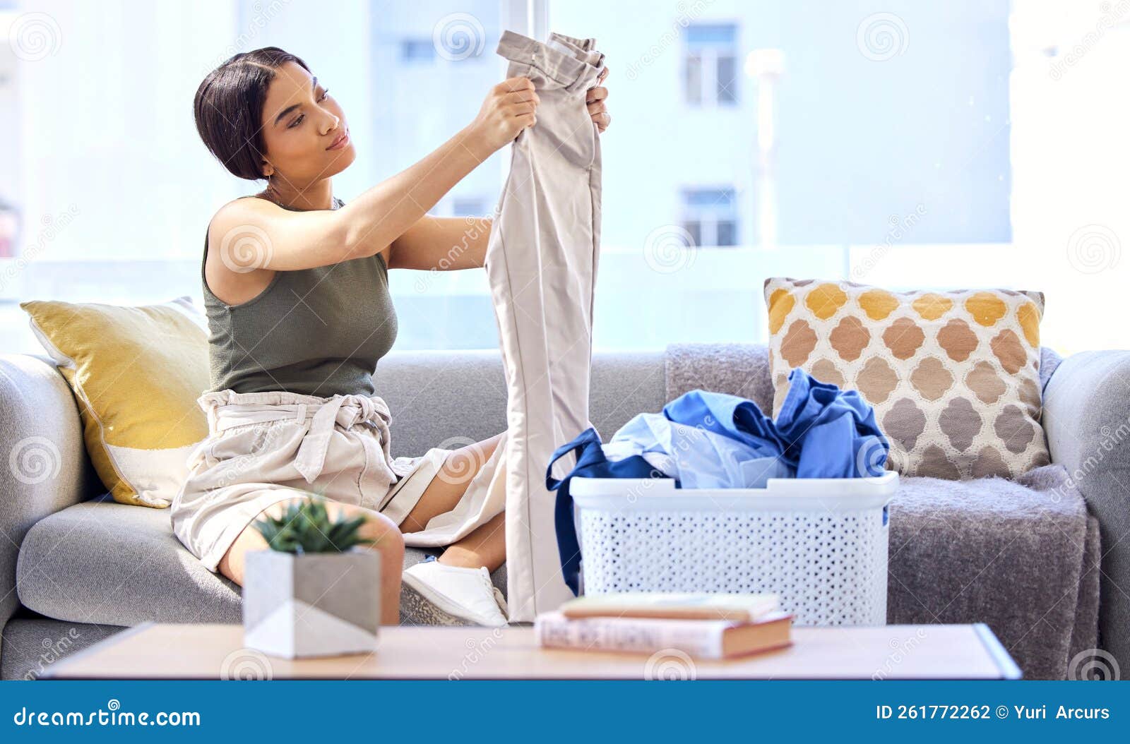 Laundry Housekeeping And Woman Folding Clothes Cleaning And Working In The Living Room Of Her